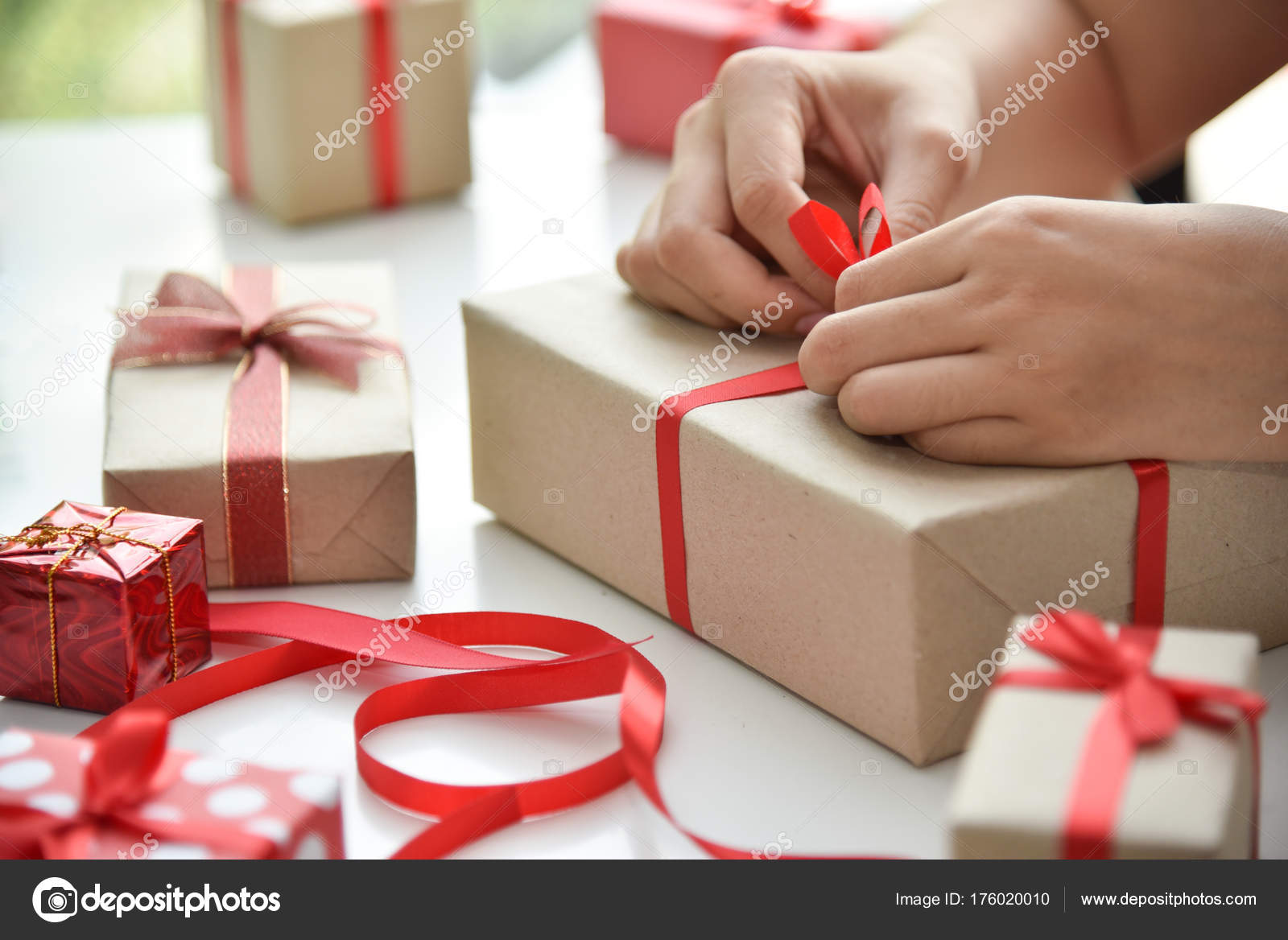 Female hands wrapping present boxes. — Stock Photo © eggeeggjiew #176020010
