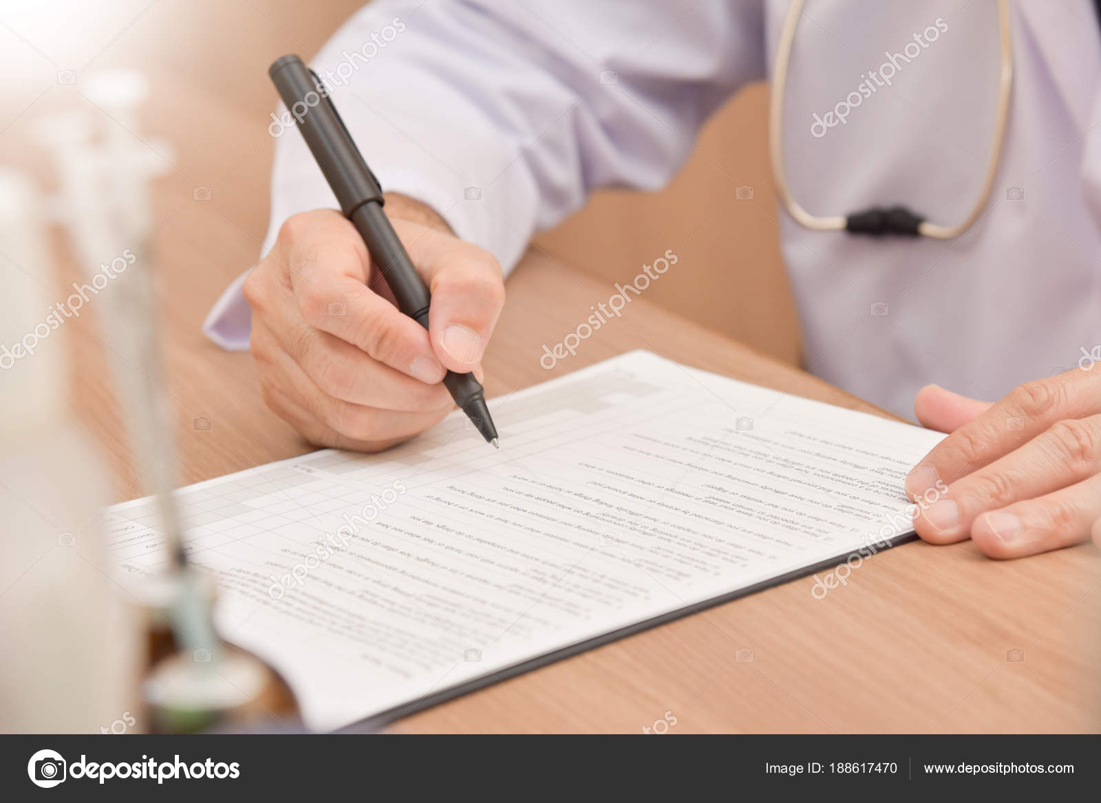Asian male doctor is writing something on clipboard. — Stock Photo ...