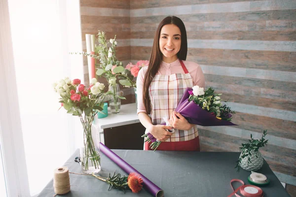 Female florist at work: pretty young dark-haired woman making fashion ...