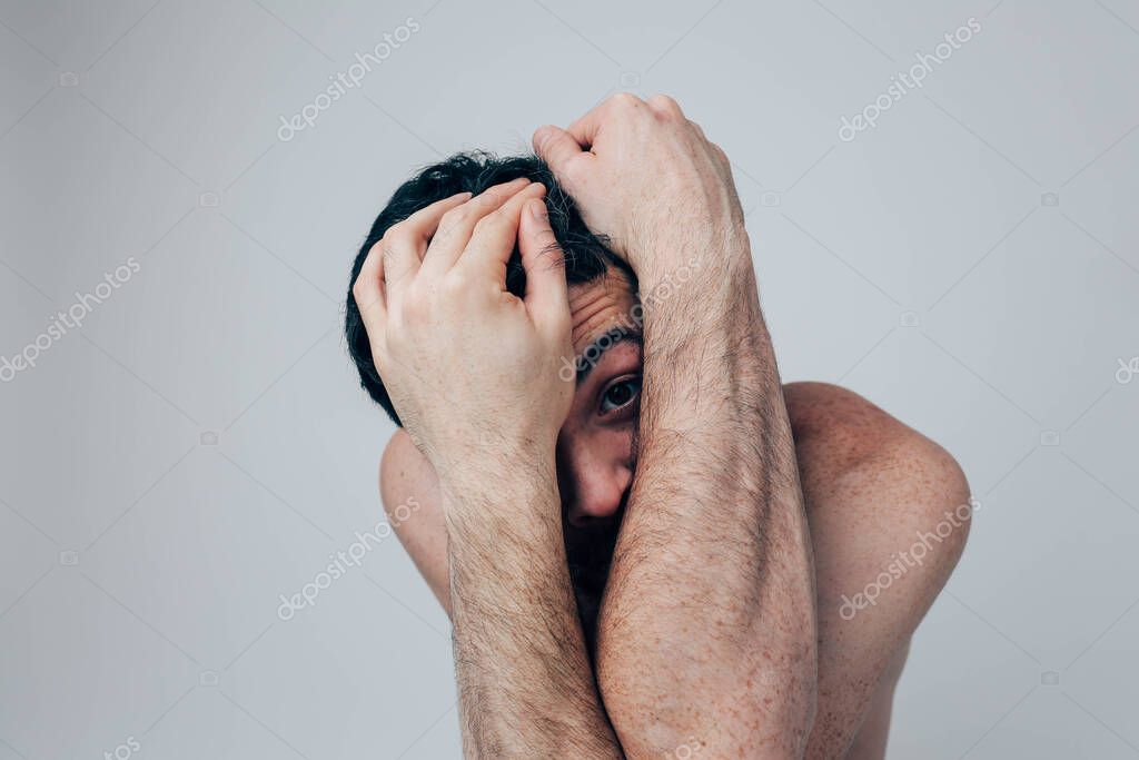 Un joven aislado sobre el fondo. El enfermo loco enfermo mira directo a ...