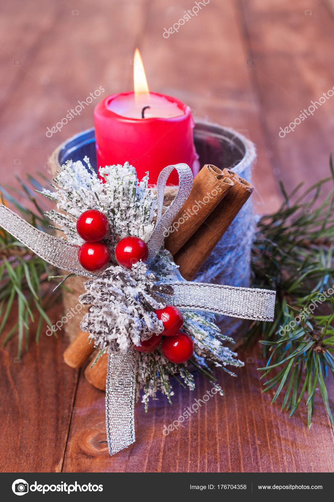 Red hot candle in a homemade candlestick on a wooden table. Close-up ...