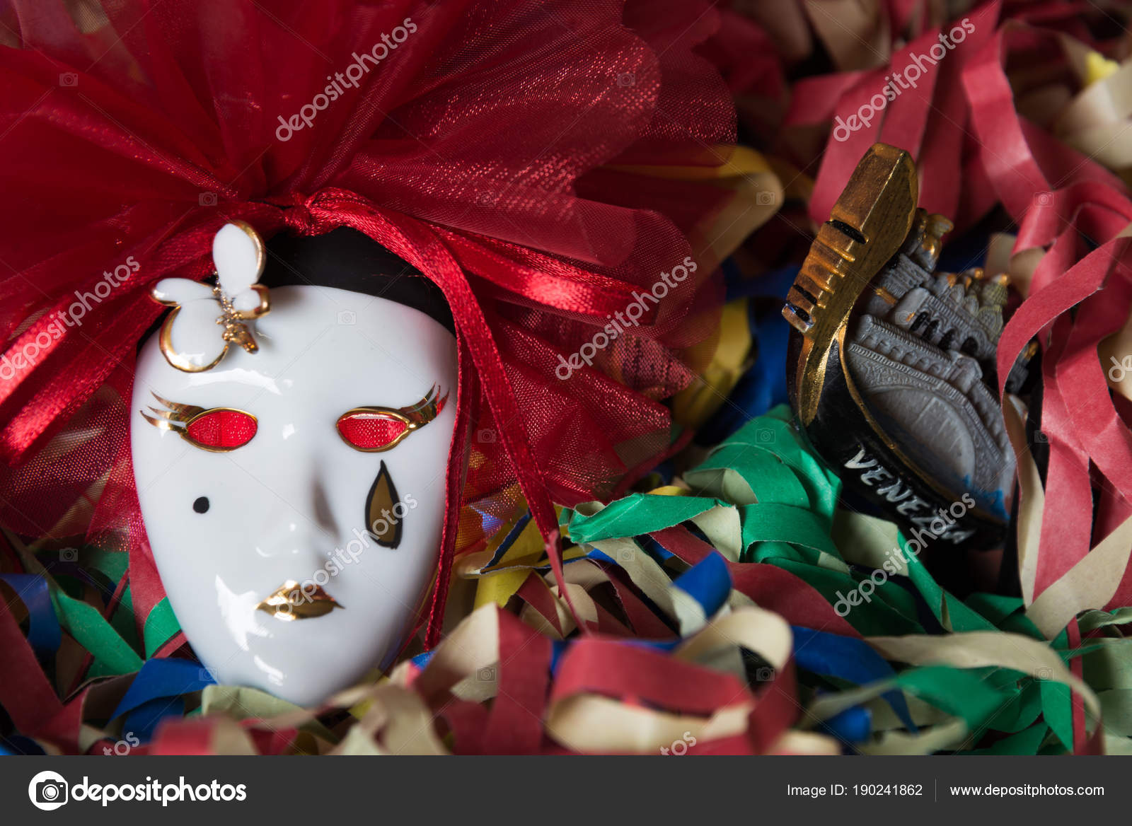 Close-up of Pierrot carnival mask on a background of colored str ...