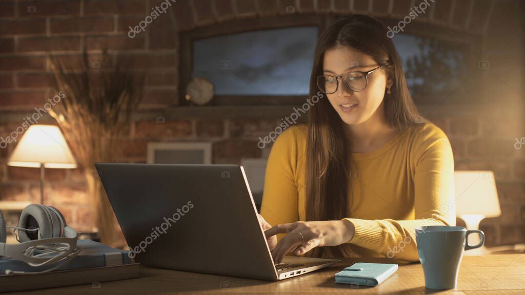 Mujer joven y feliz sentada en el escritorio en casa y charlando con su ...