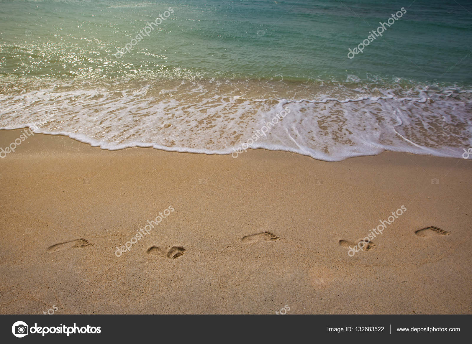 Wave and footsteps on beach — Stock Photo © AnnaTamila #132683522