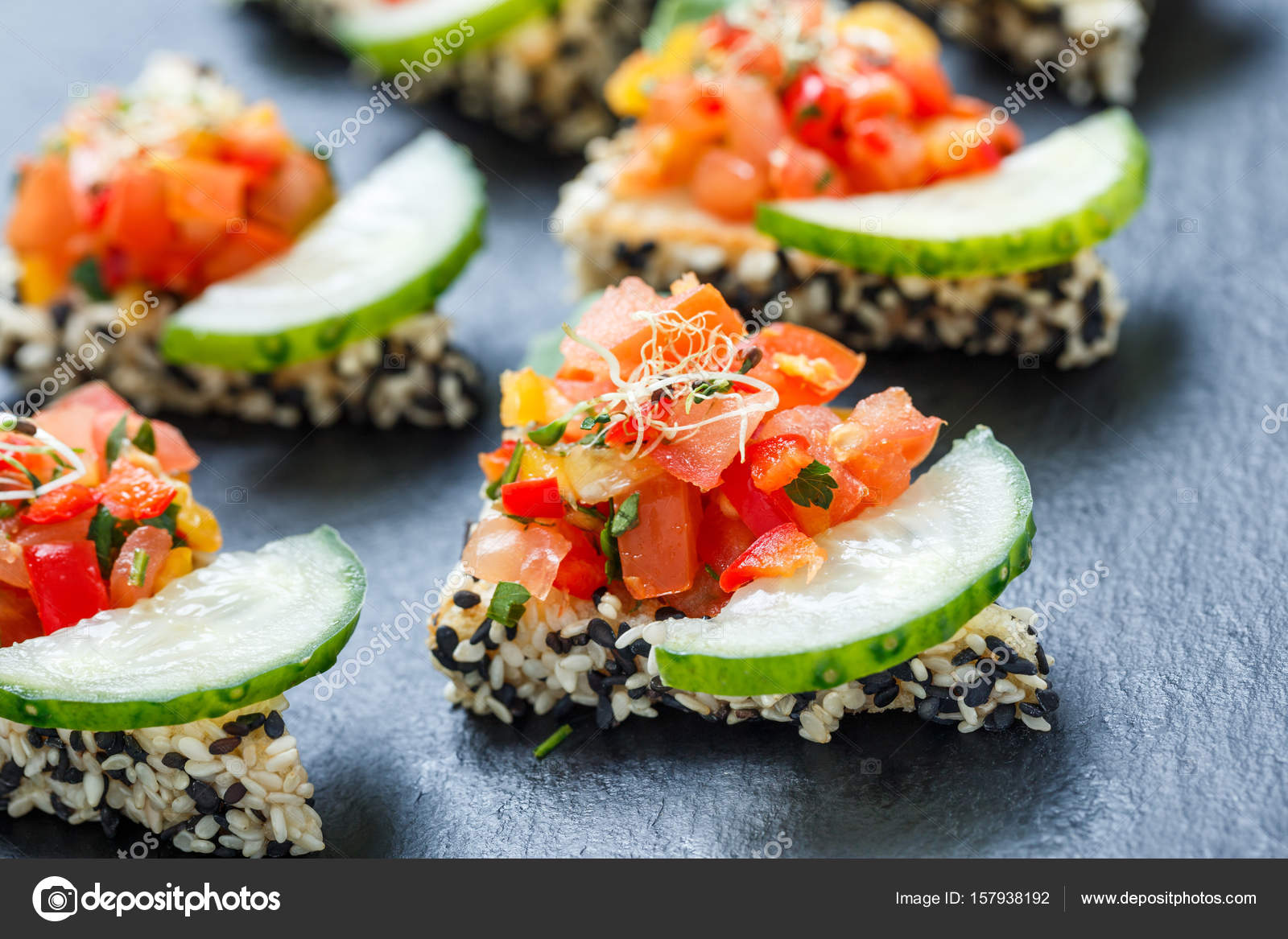 Appetizer canape with chopped vegetables and sesame on stone slate ...