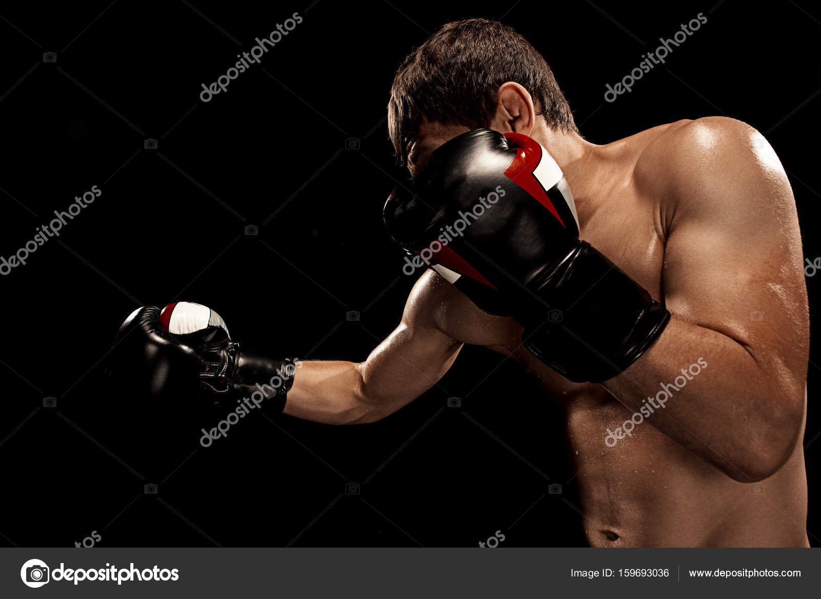 Male boxer boxing in punching bag with dramatic edgy lighting in a dark ...