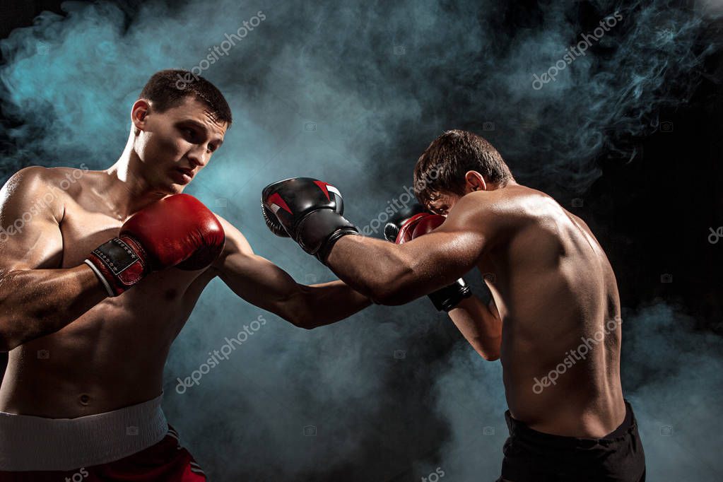 Dos boxeadores profesionales boxeando sobre fondo ahumado negro, 2023