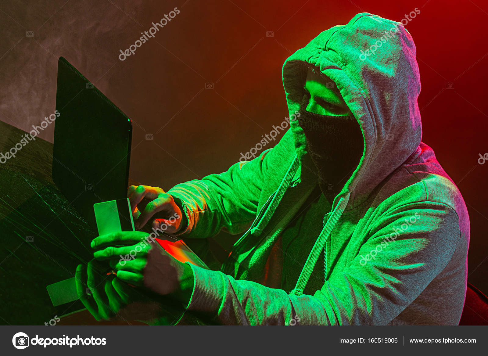 Hooded computer hacker stealing information with laptop — Stock Photo © vova130555@gmail.com ...