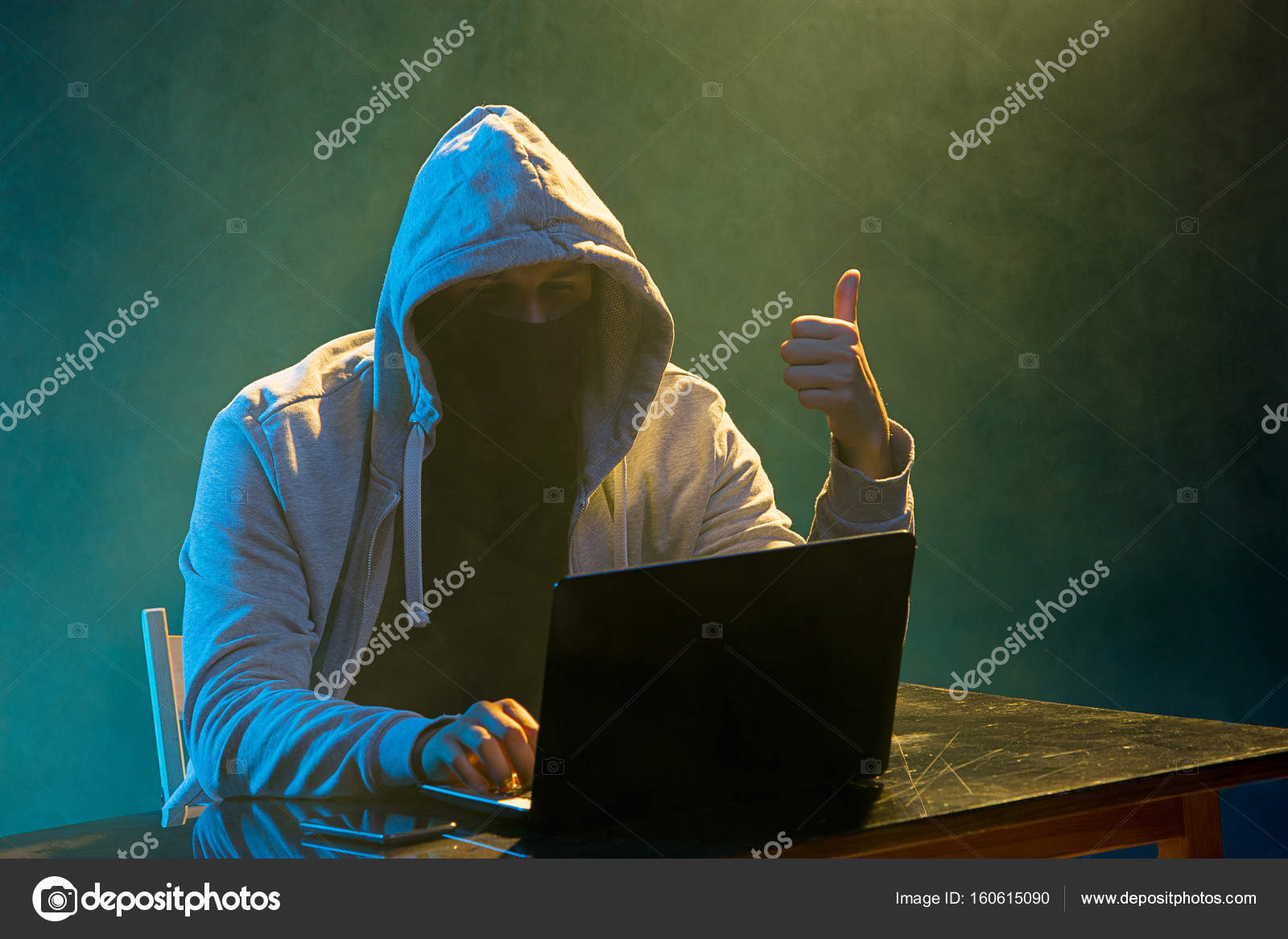 Hooded computer hacker stealing information with laptop — Stock Photo © vova130555@gmail.com ...