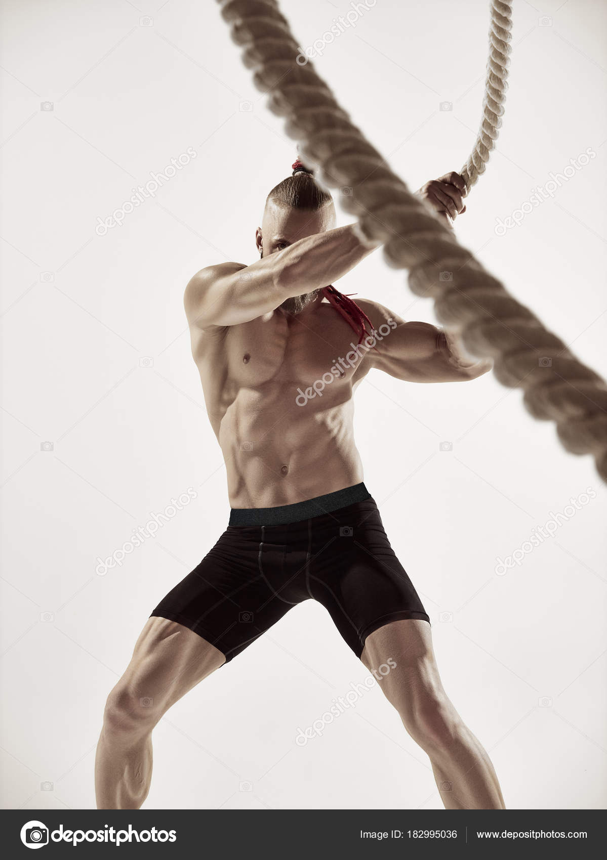 Attractive muscular man working out with heavy ropes. Stock Photo by ...