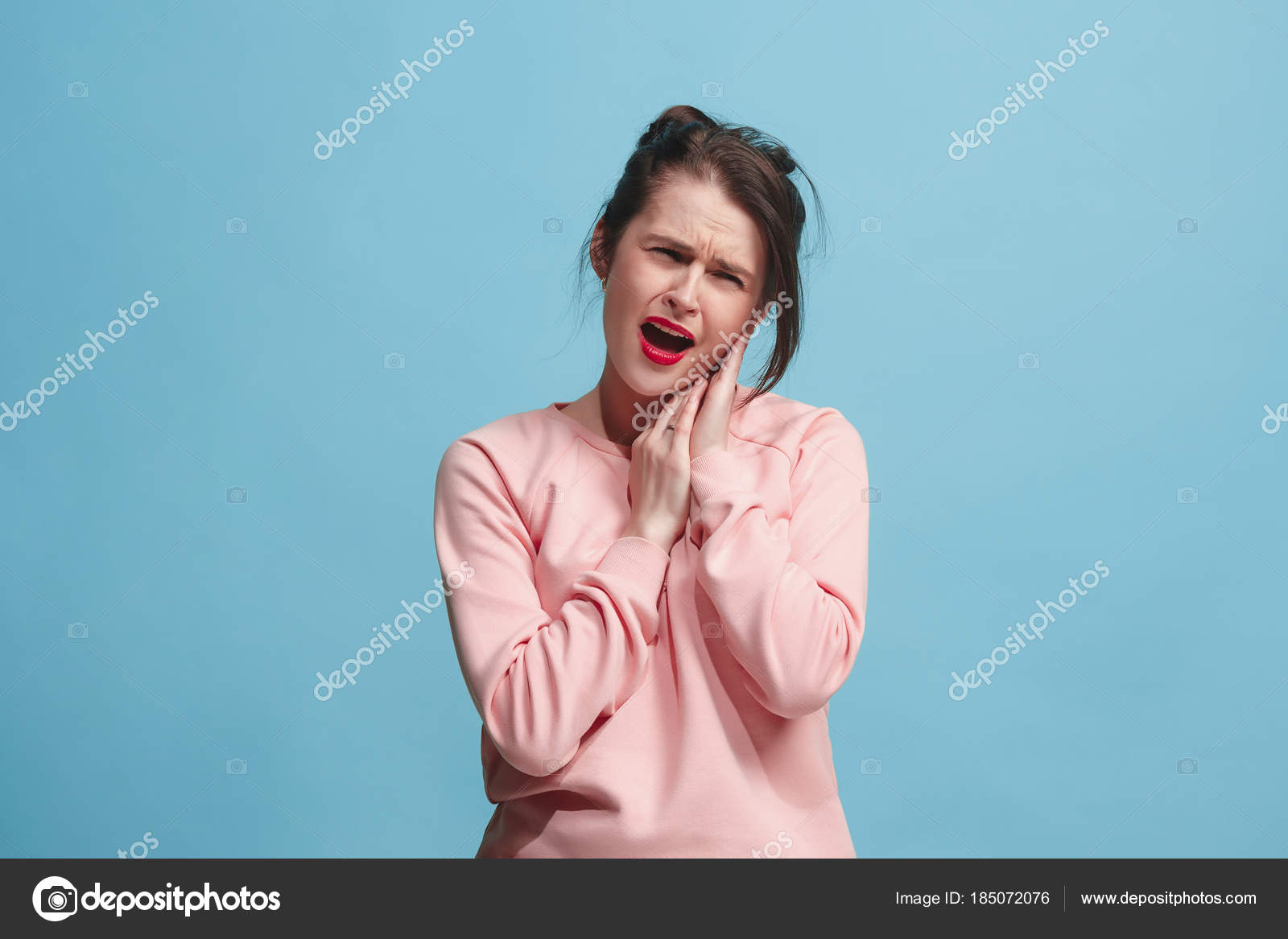 The Ear ache. The sad woman with headache or pain on a blue studio ...