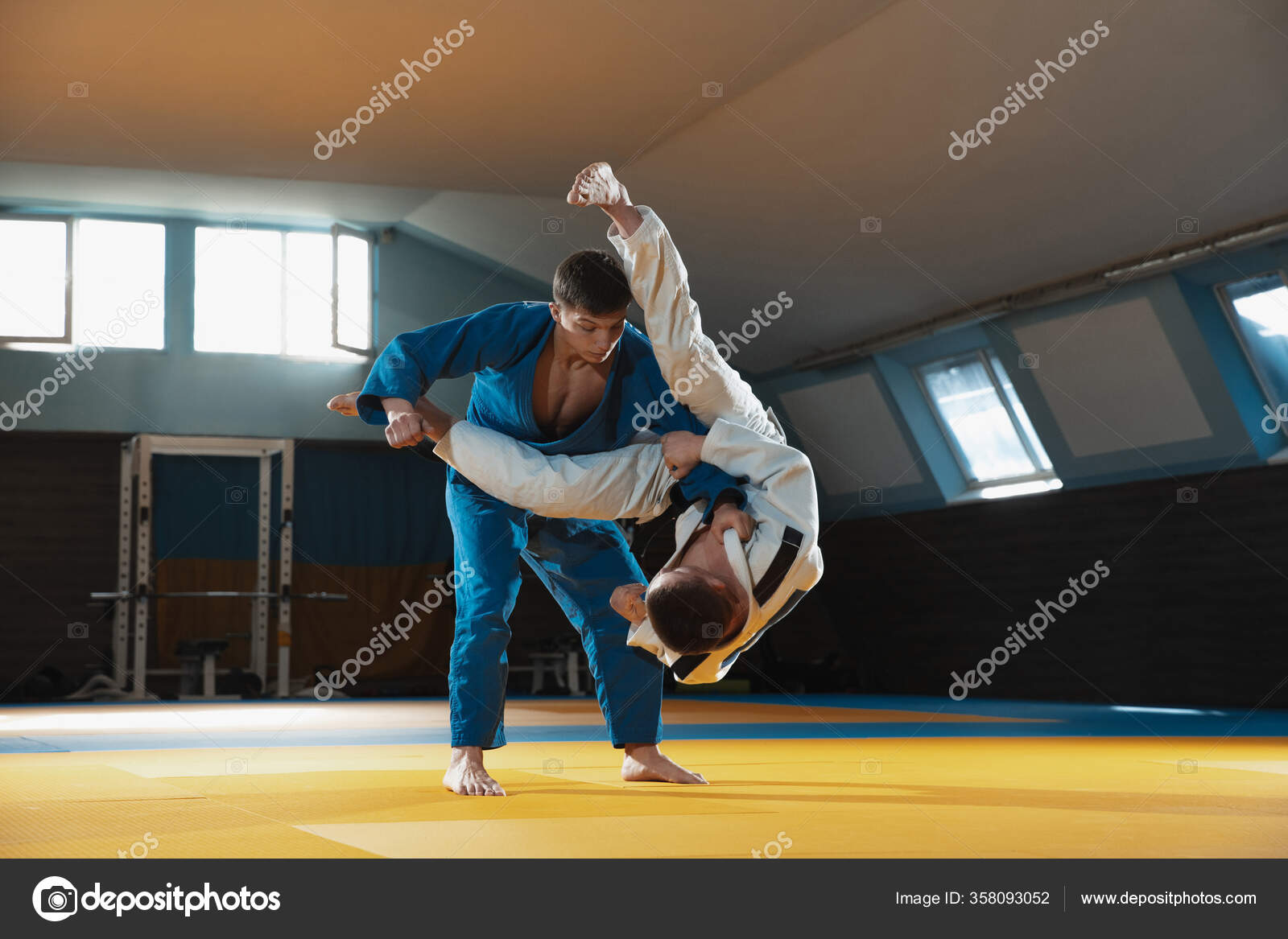 Two young judo fighters in kimono training martial arts in the gym with ...