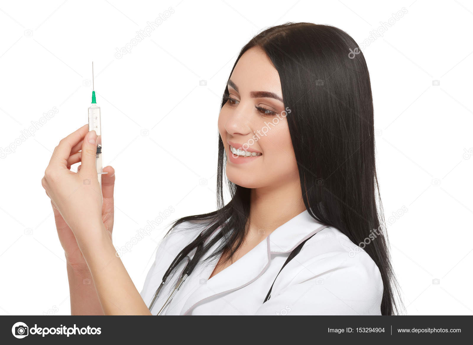A portrait of a young female doctor smiling with a syringe in her hand ...