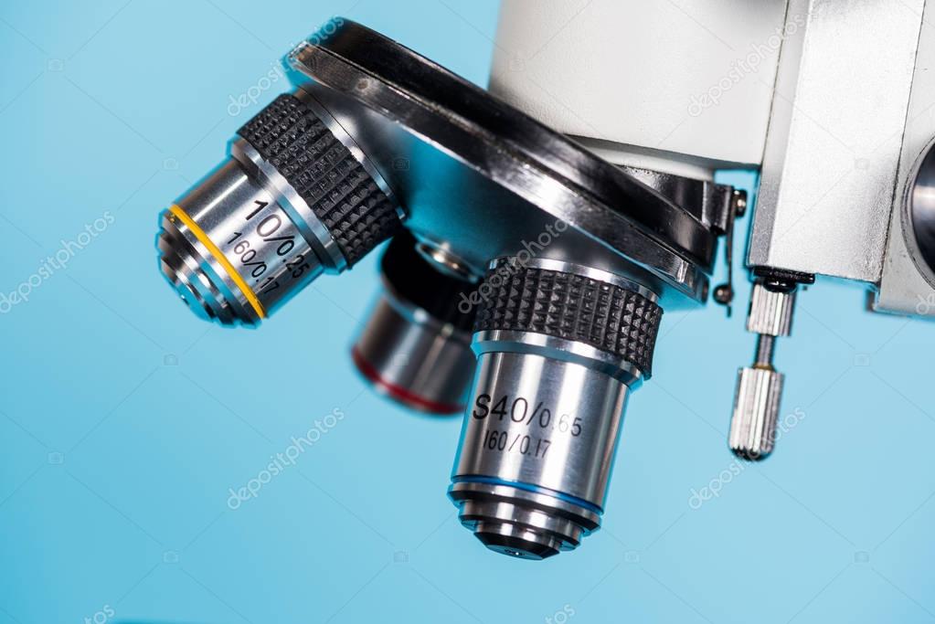 Close up of microscope len on light blue background — Stock Photo ...