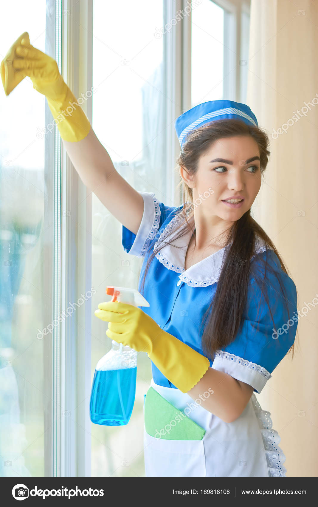 Housemaid wiping a window. — Stock Photo © Denisfilm #169818108