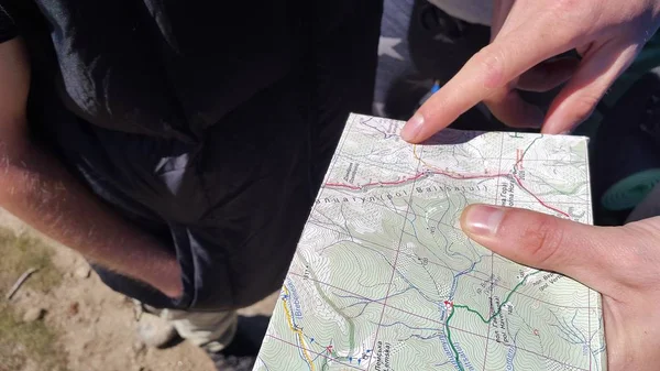 Indicates the map with your finger. Tourists dokladyvaet route. - Stock ...