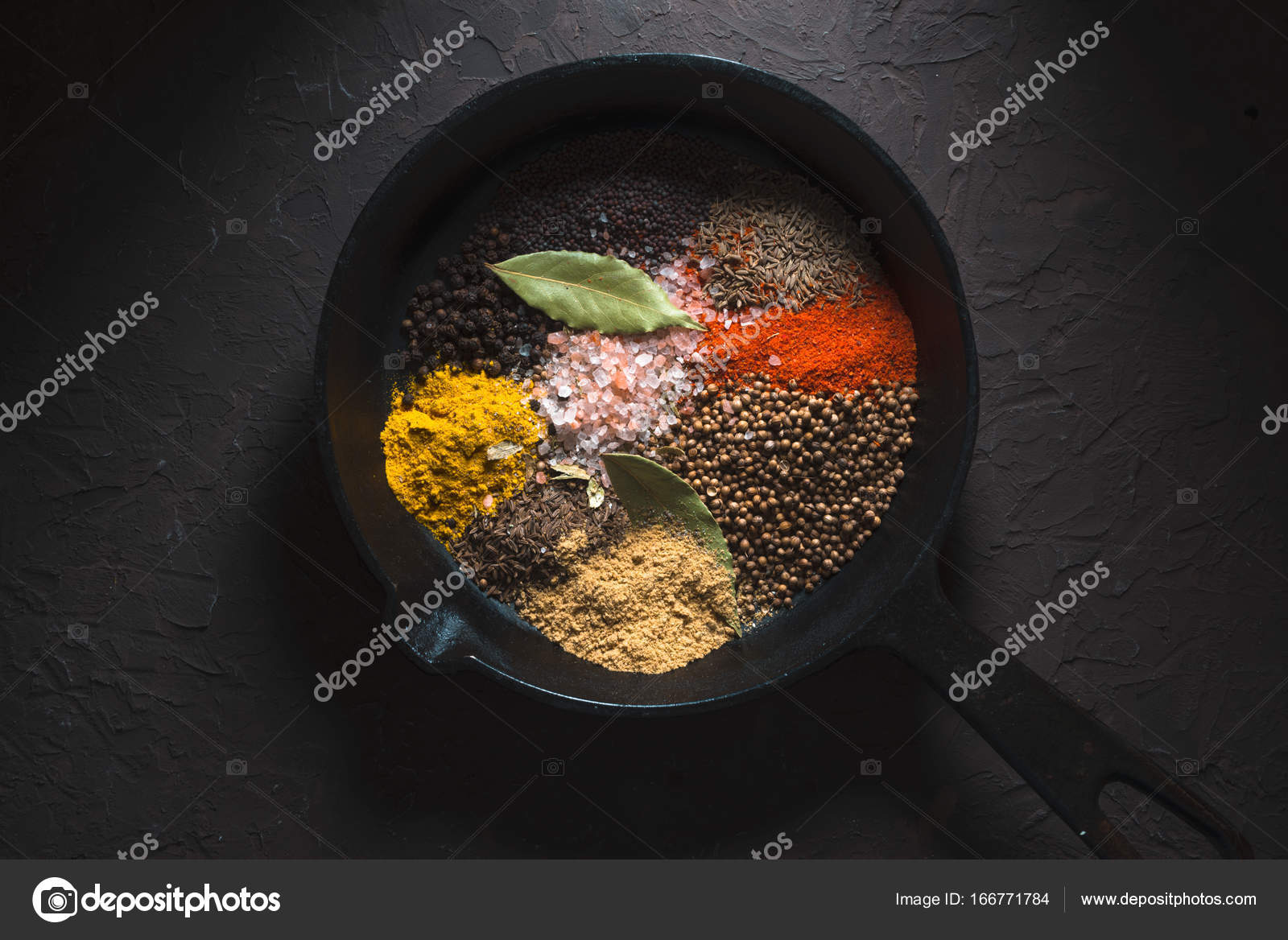 Different spices for Indian masala in the pan on the dark background ...