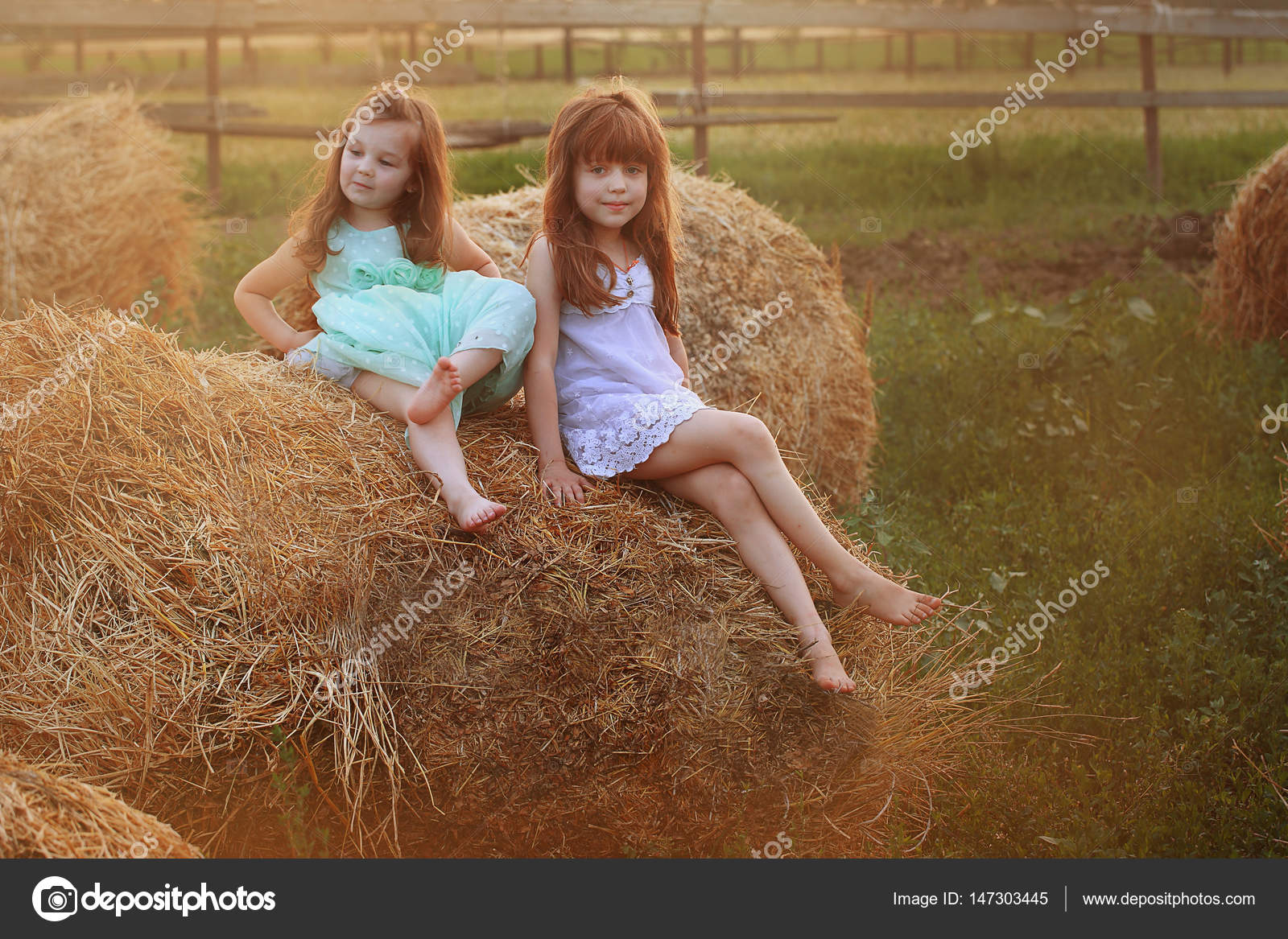 Two girls sitting on a haystack Stock Photo by ©DmZo 147303445