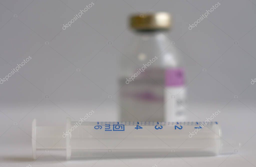 Primer plano de la jeringa, sobre el vial de fondo de antibióticos ...