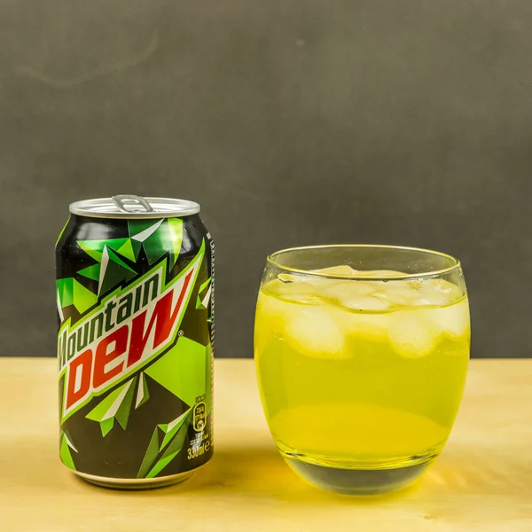A glass of Mountain Dew with ice cubes held in hand. – Stock Editorial ...