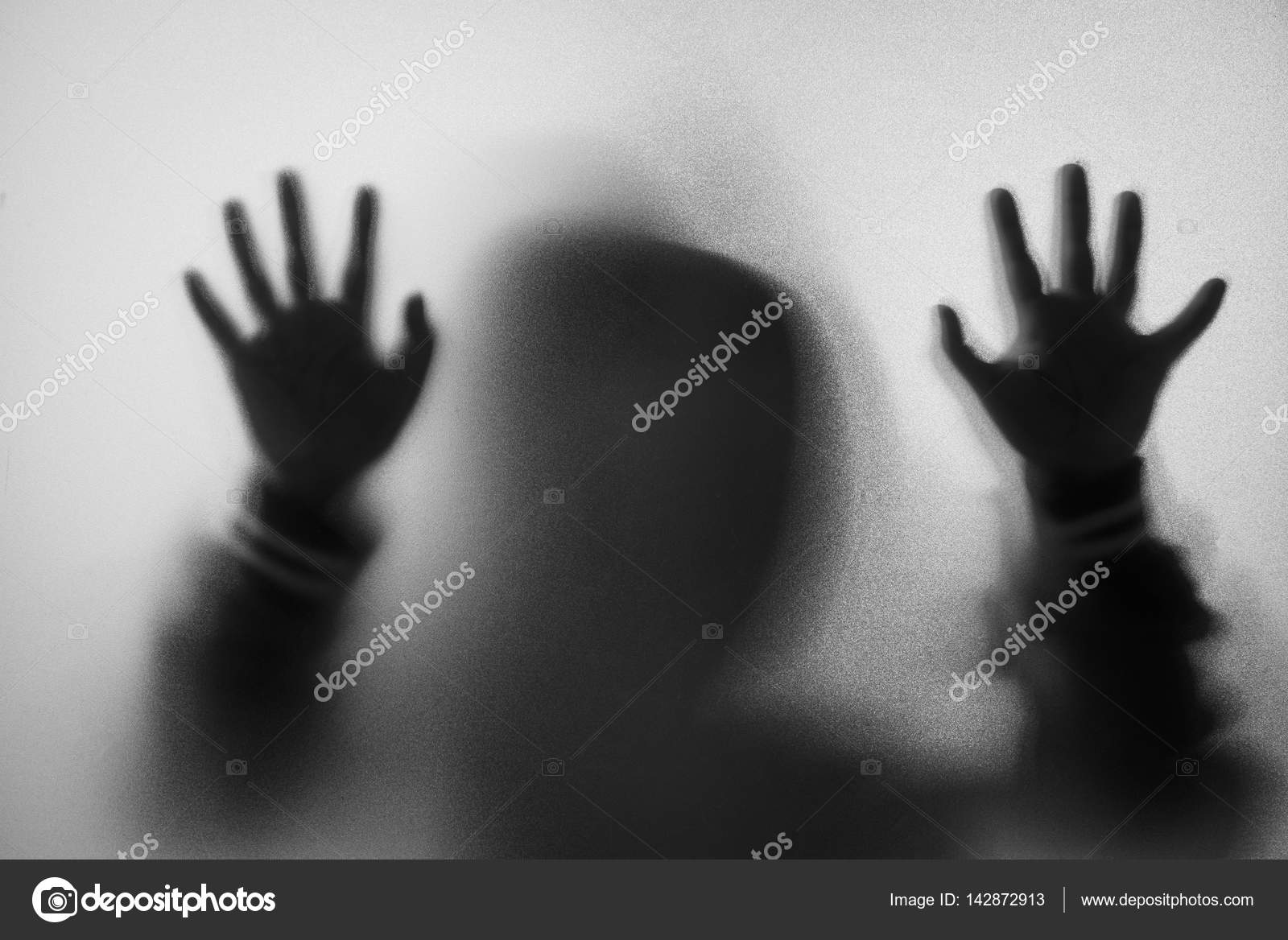 Shadow blur of horror man in jacket with hood.Hands on the glass ...