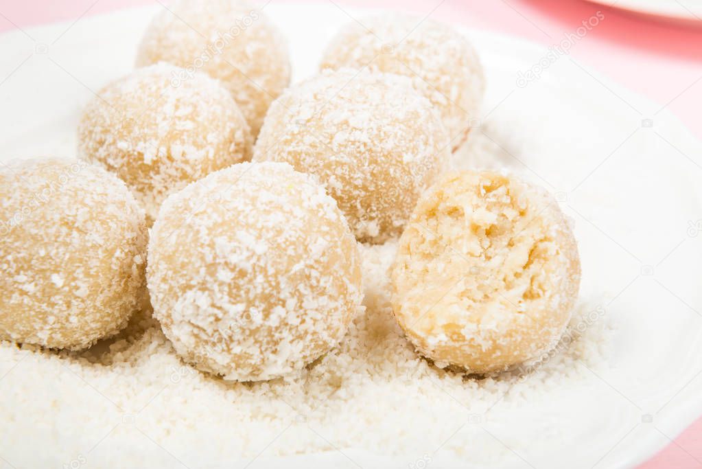 Trufas de coco y limón veganas crudas caseras sobre fondo rosa 2024