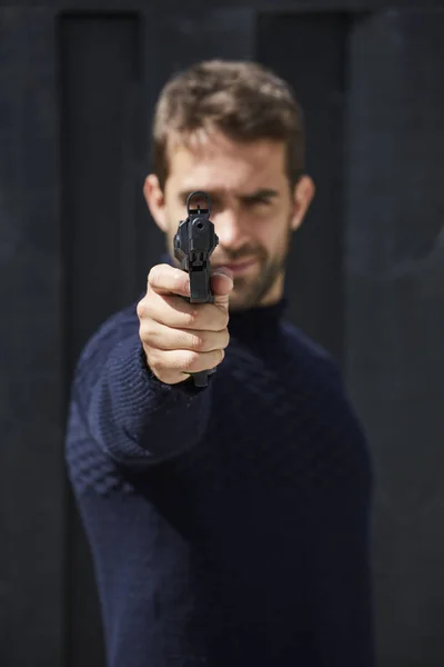 Guy with gun aiming at camera - Stock Image - Everypixel