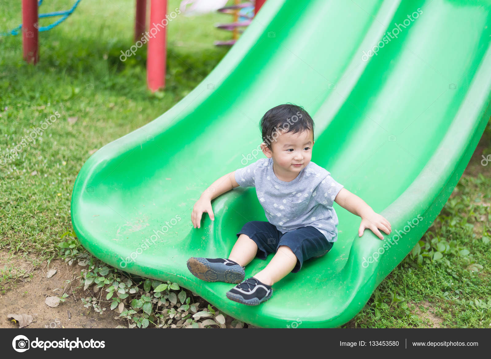 Little Asian kid playing slide at the playground — Stock Photo ...