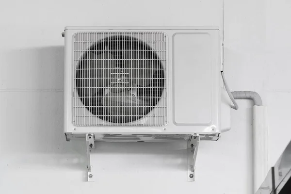Air conditioner compressor unit on white wall. - Stock Image - Everypixel