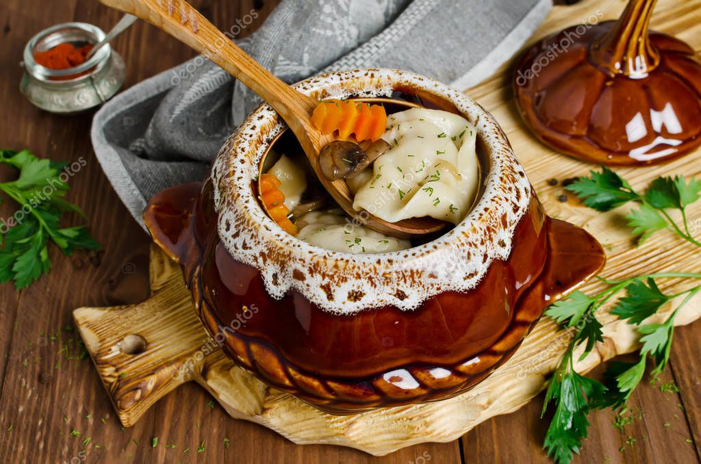 Dumplings en una olla sobre una mesa de madera 2023