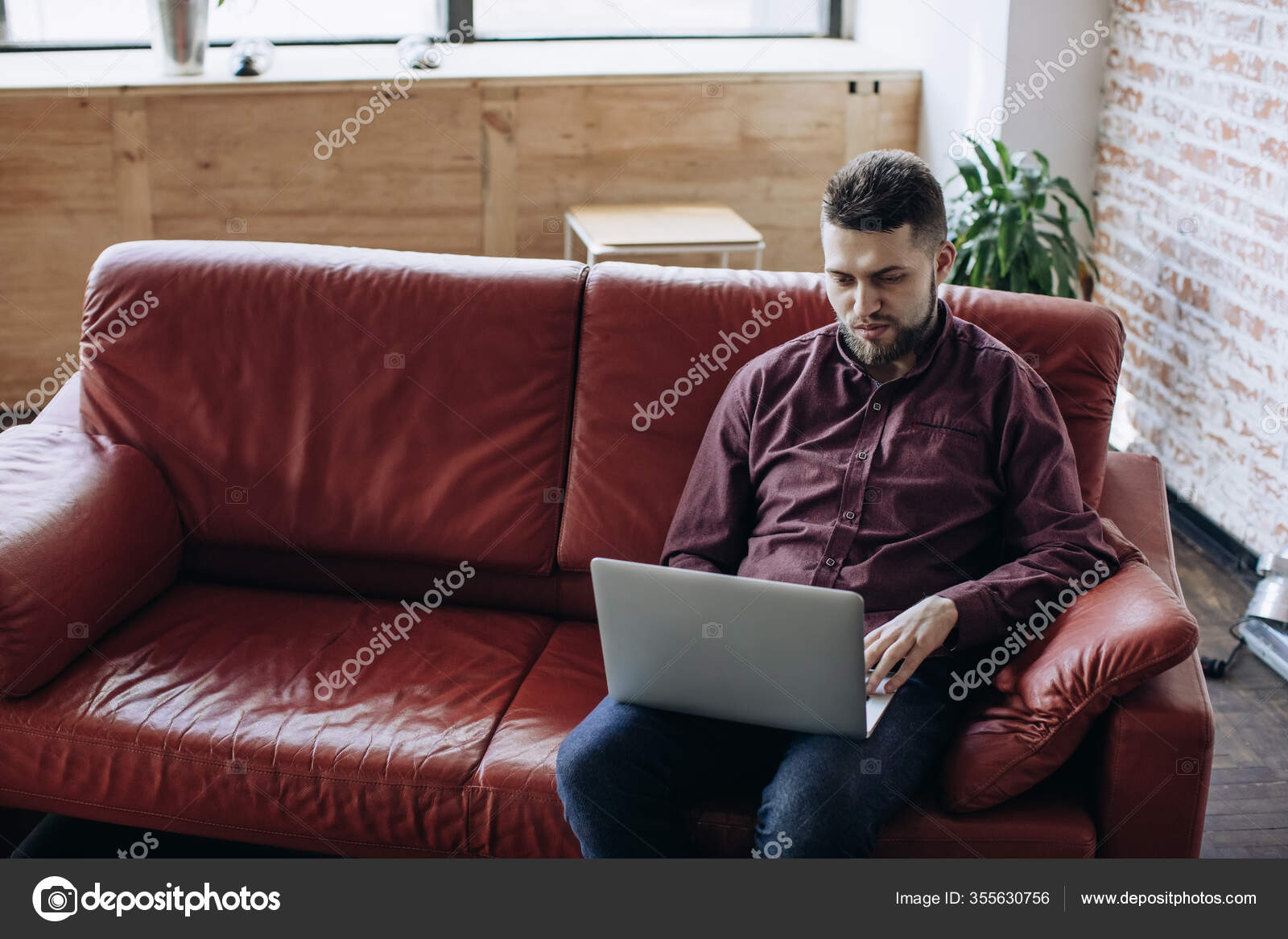 Young Man Sitting Sofa Using Laptop Stock Photo by ©beorm 355630756