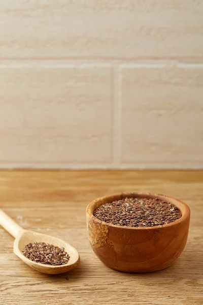 Wooden spoon with flax seeds on rustic background, top view, close-up, shallow depth of field ...
