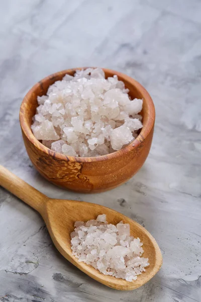 Large white sea salt in a natural wooden bowl on light background, top ...