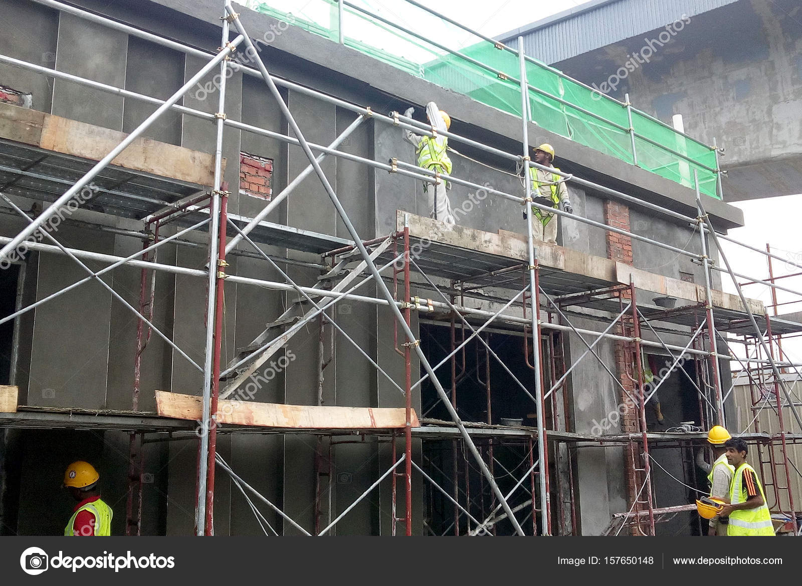 Construction workers plastering building wall and beam using cement ...