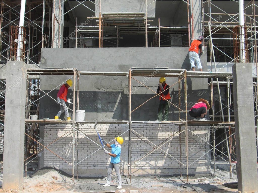 Construction workers plastering building wall and beam using cement ...