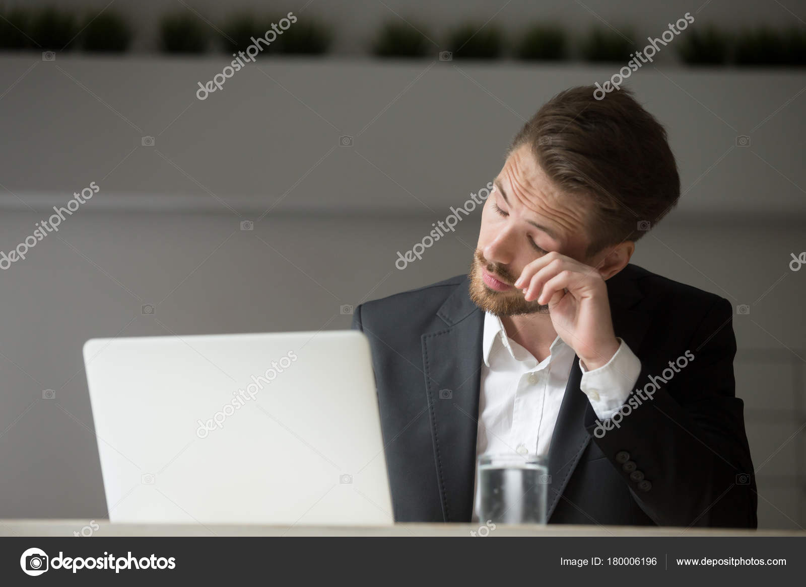 Overworked businessman wearing suit feeling tired from work on l ...