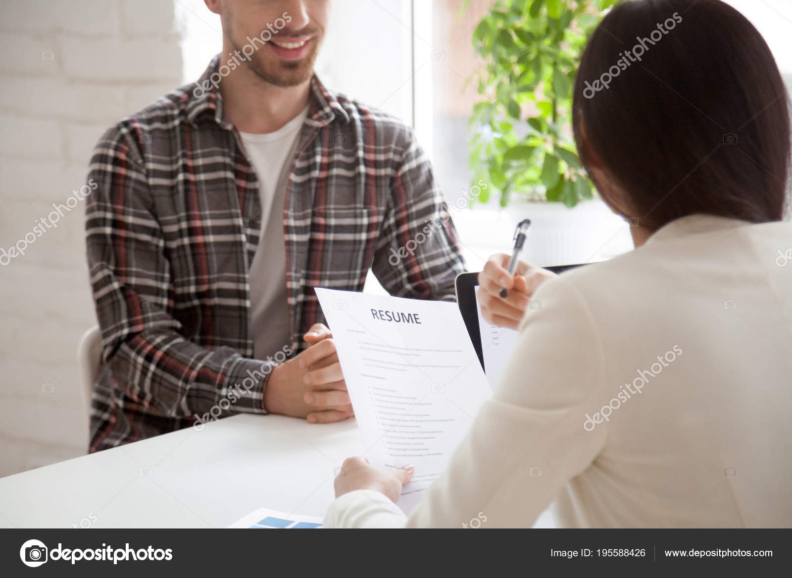Hr manager holding reading smiling applicants resume at job inte ...