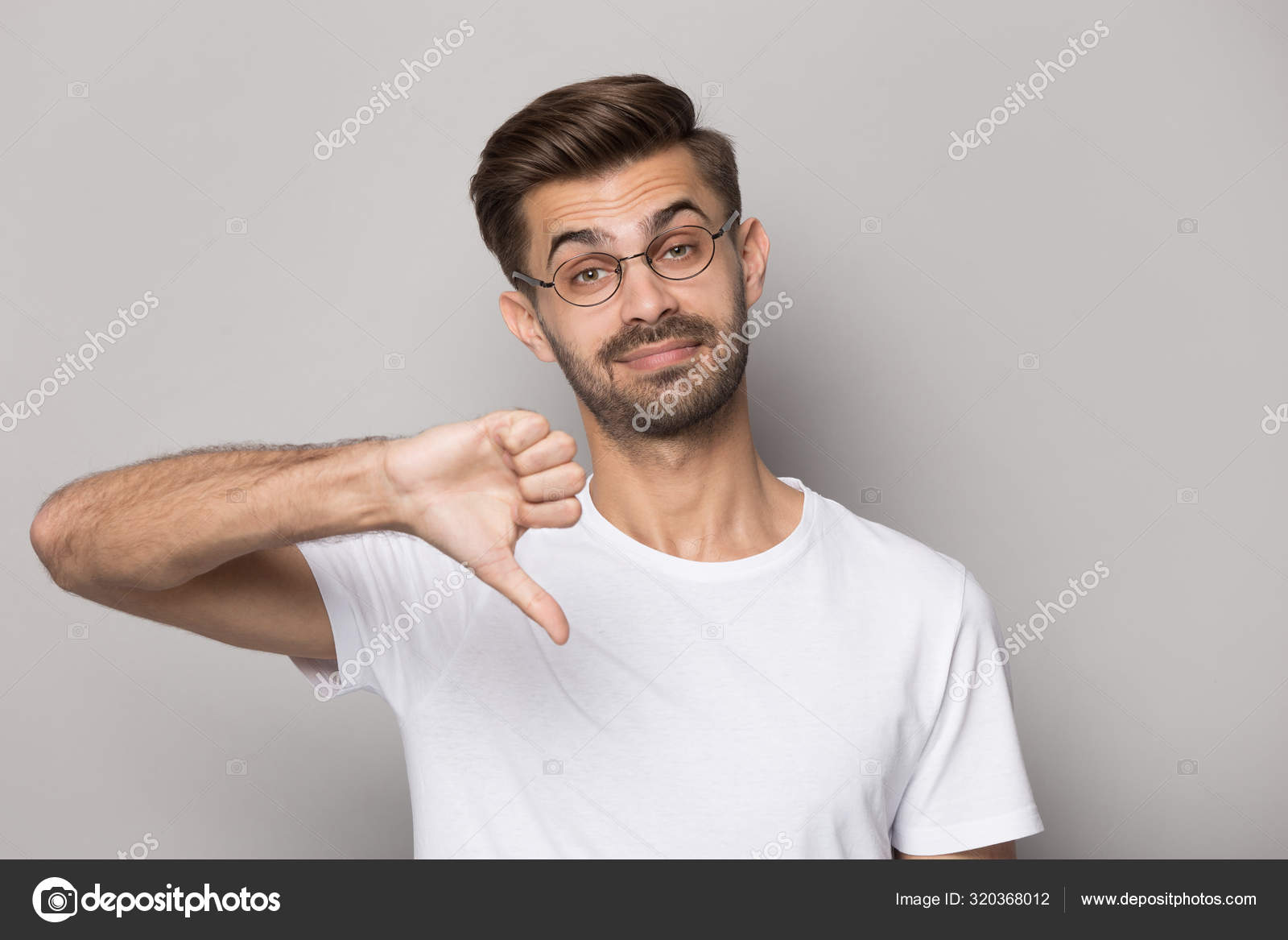 Close up portrait with handsome bearded man dislikes with gesture ...