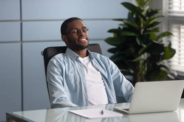 Calm african American employee relax in chair at work - Stock Image ...