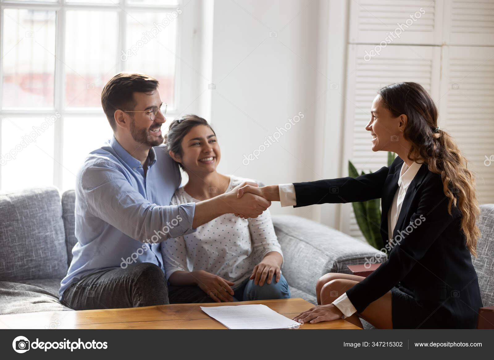 Realtor handshaking with couple after signing rental agreement — Stock ...
