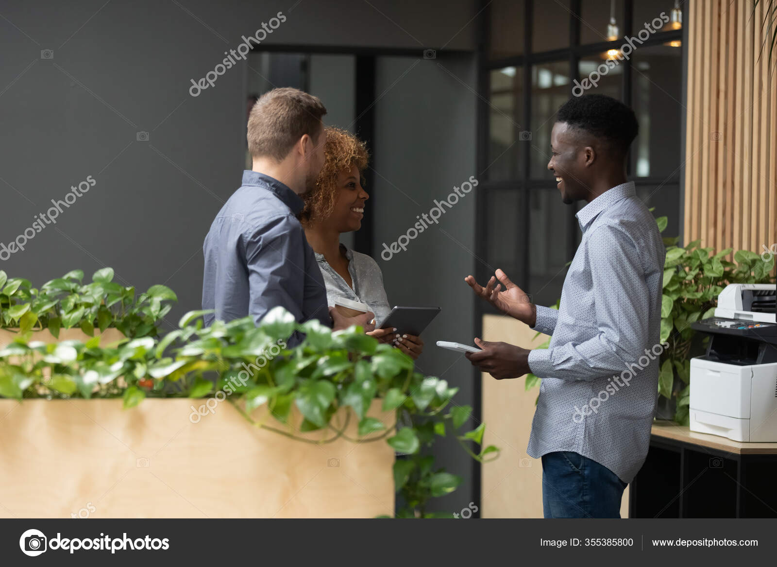 Smiling diverse employees talking, chatting in office during break ...