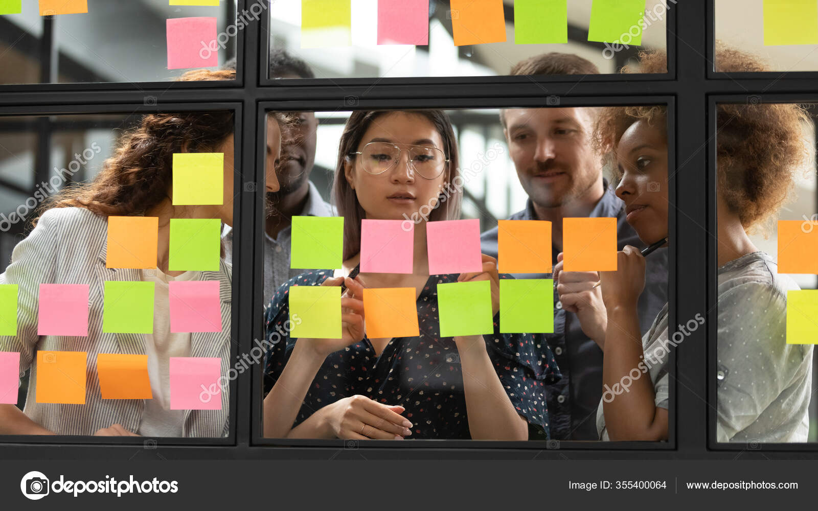 Diverse businesspeople discussing, planning project on sticky papers ...