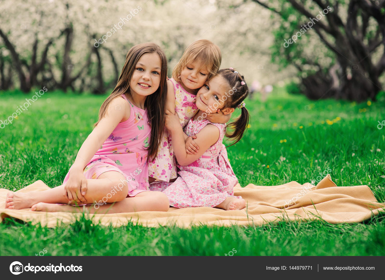 Three little sisters having a lot of fun playing together outdoor in ...