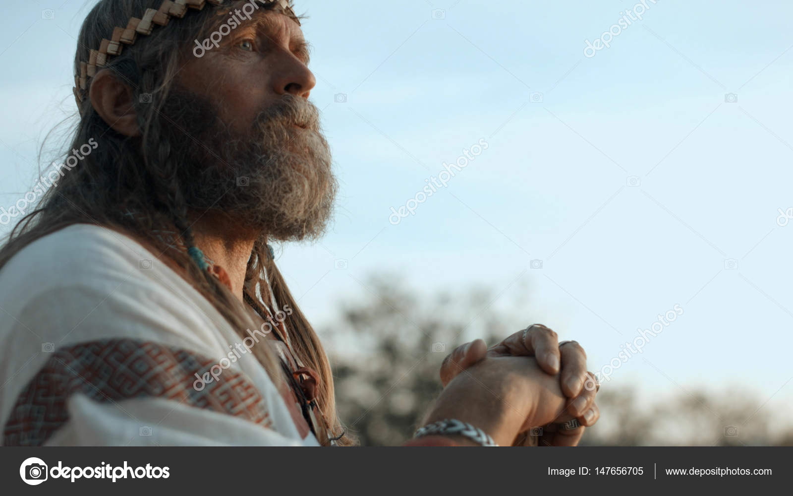 Old pagan in medieval clothes standing and looking into the distance ...