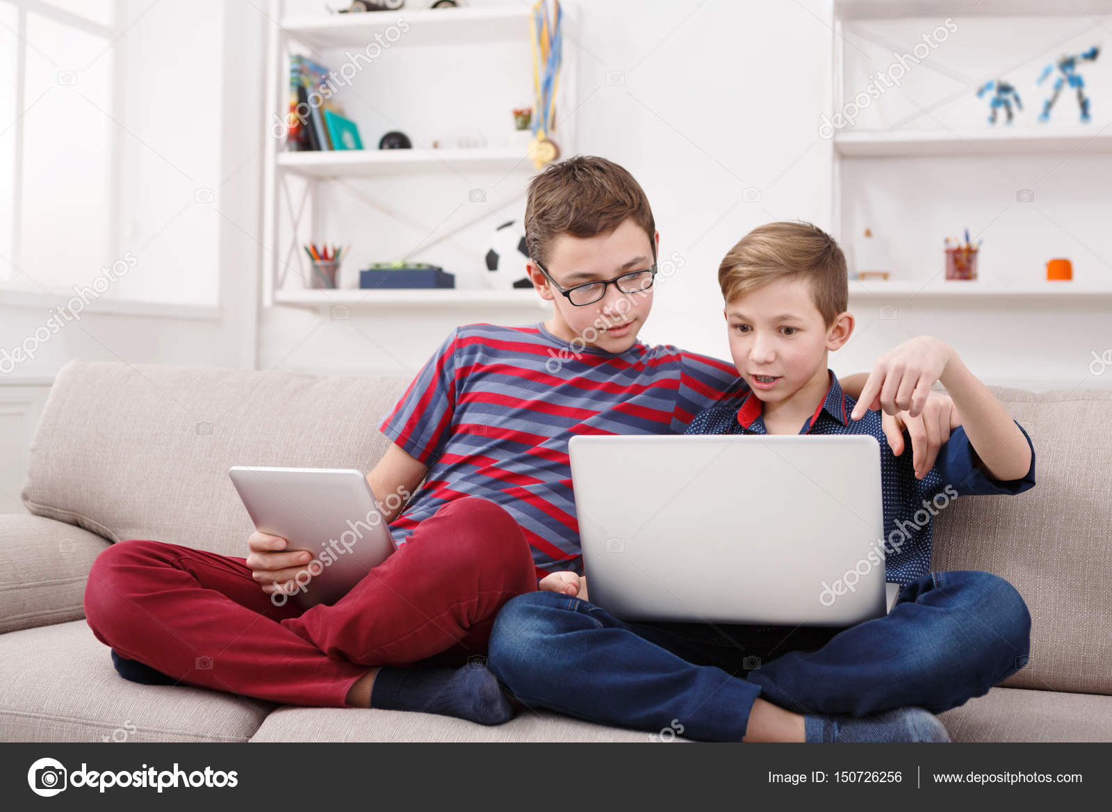 Deux Adolescents Utilisant Une Tablette Sur Le Canapé à La Maison Image