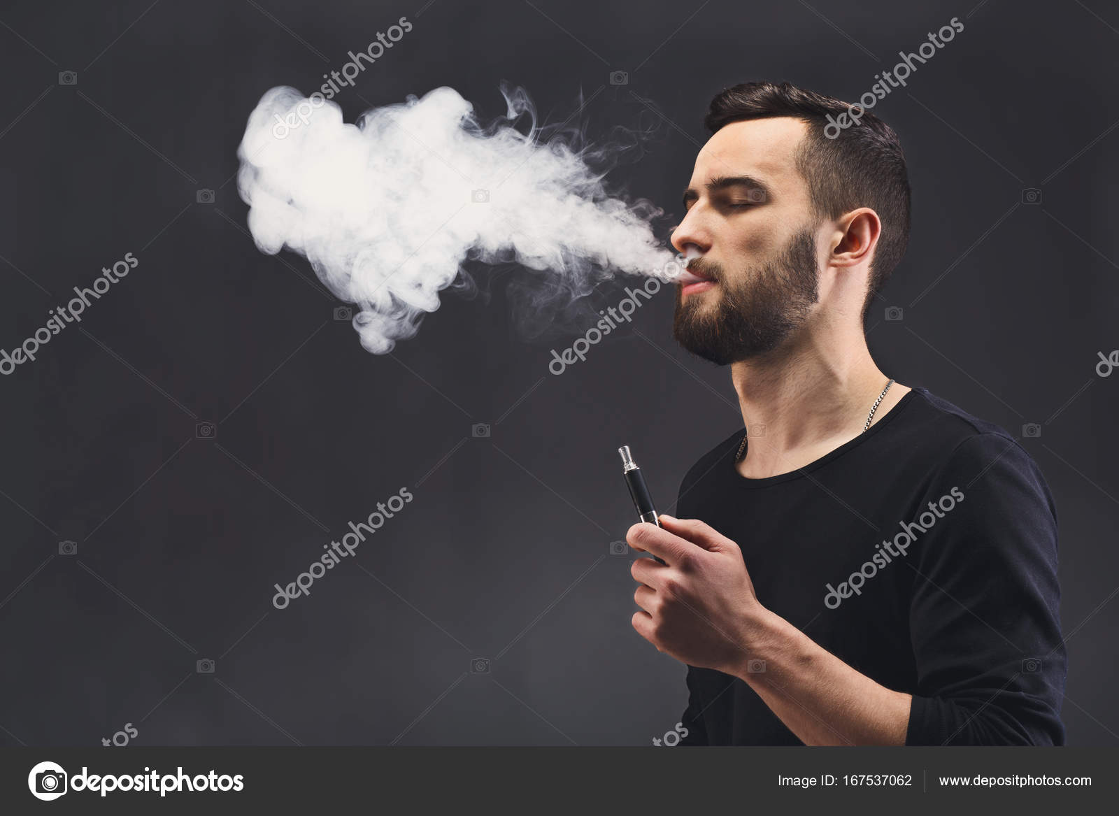 Young man vaping e-cigarette with smoke on black — Stock Photo © Milkos ...