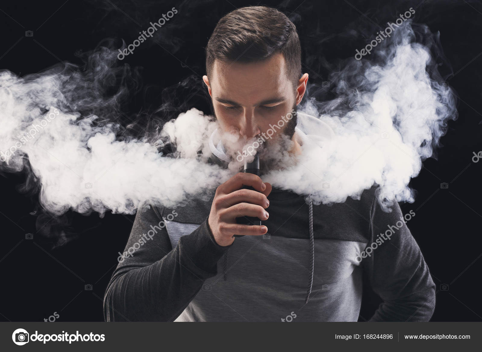 Young man vaping e-cigarette with smoke on black Stock Photo by ©Milkos ...