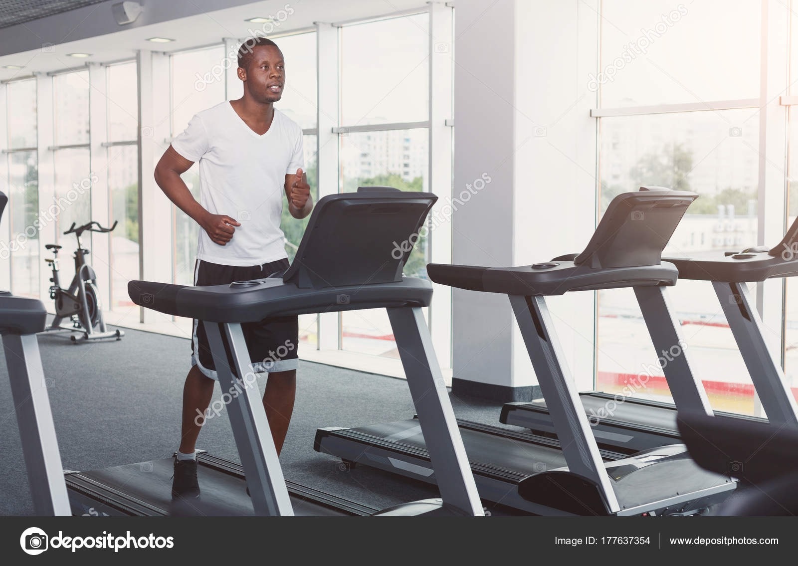 Young man in gym run on treadmill — Stock Photo © Milkos #177637354