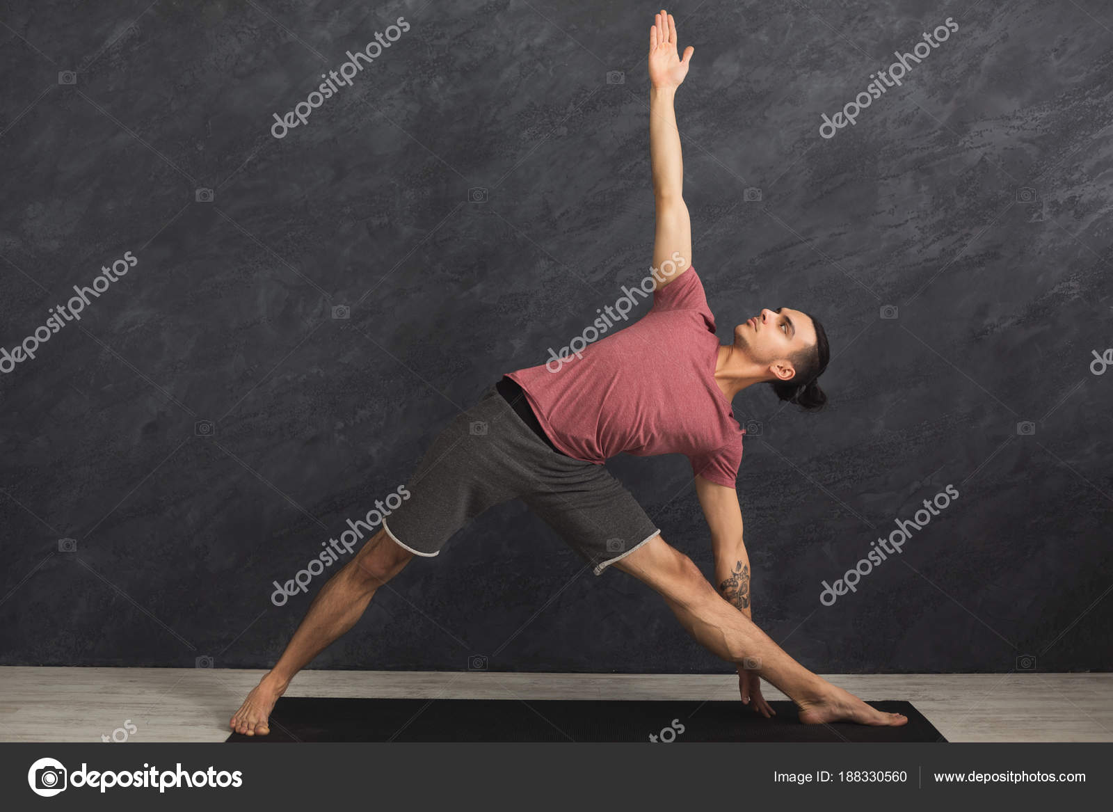 Man stretching hands and legs at gym Stock Photo by ©Milkos 188330560