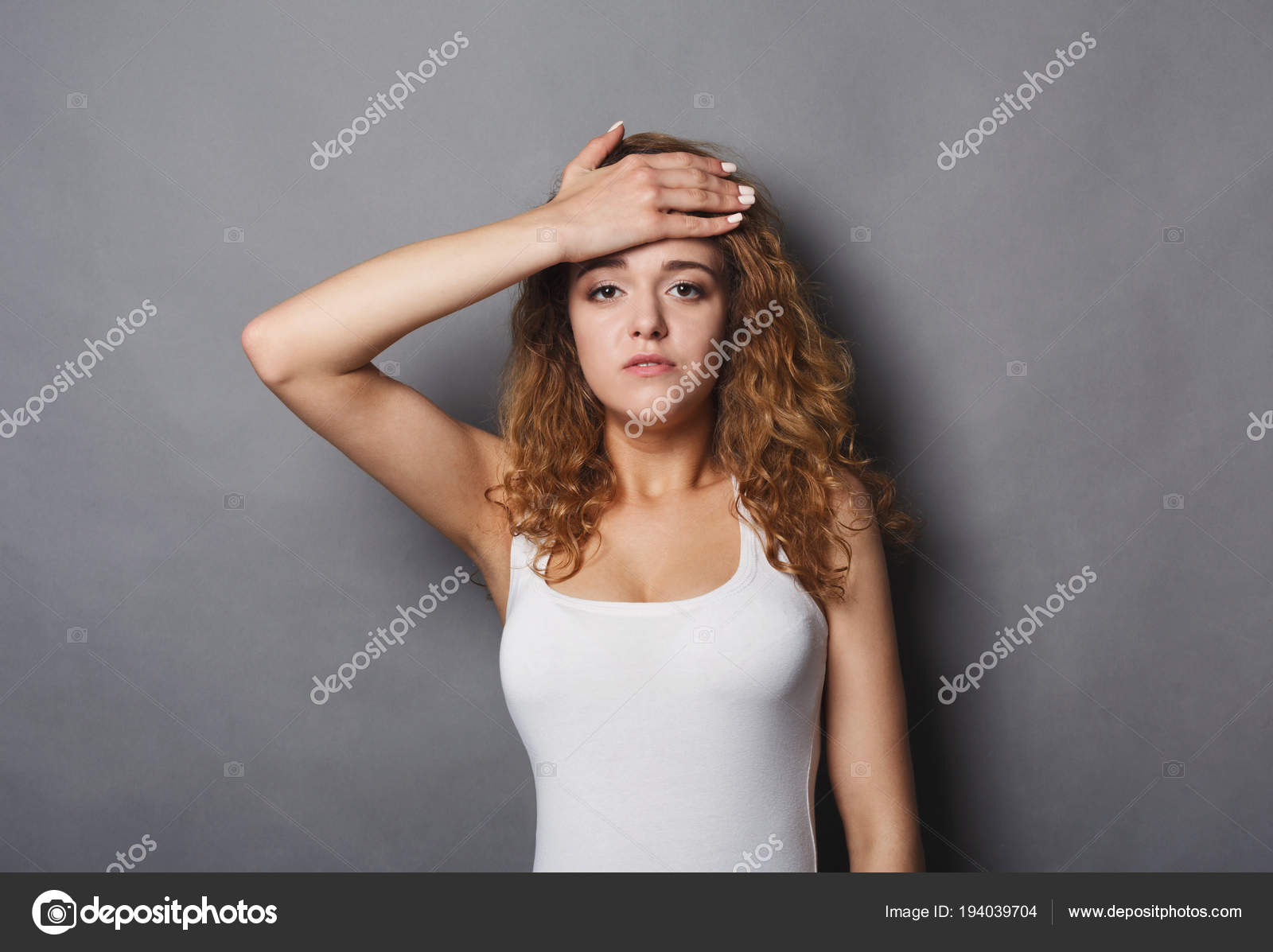 Attractive girl touching her forehead Stock Photo by ©Milkos 194039704